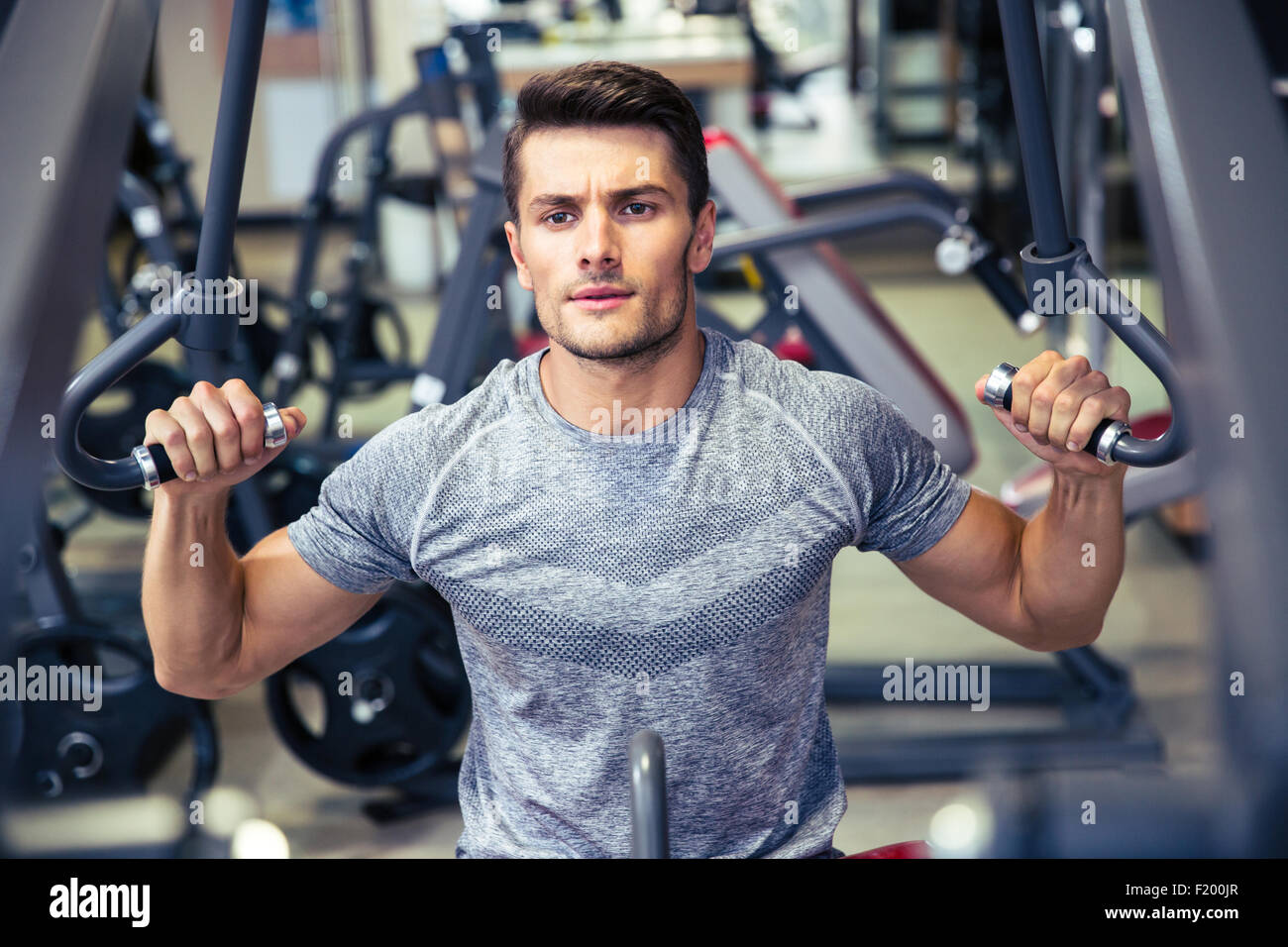 Portrait of a young bodybuilder workout on fitness machine at gym Stock ...