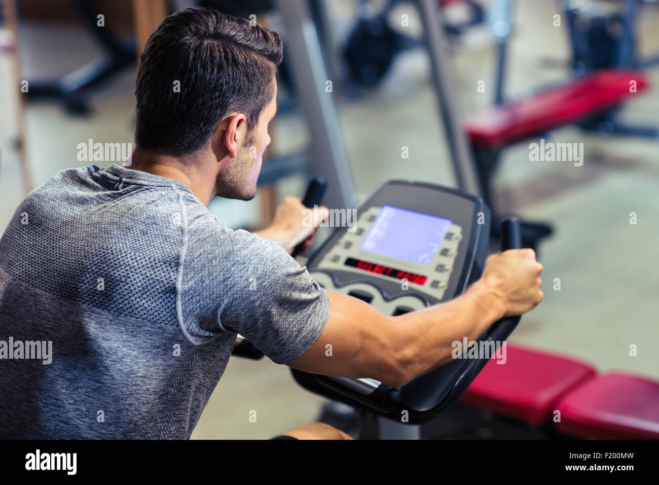 Young man workout on a fitness machine at gym Stock Photo - Alamy