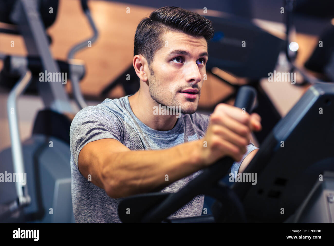 Portrait of a handsome man workout on a fitness machine at gym Stock ...