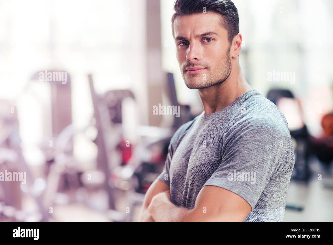 Portrait of a fitness man standing with arms folded in gym Stock Photo ...