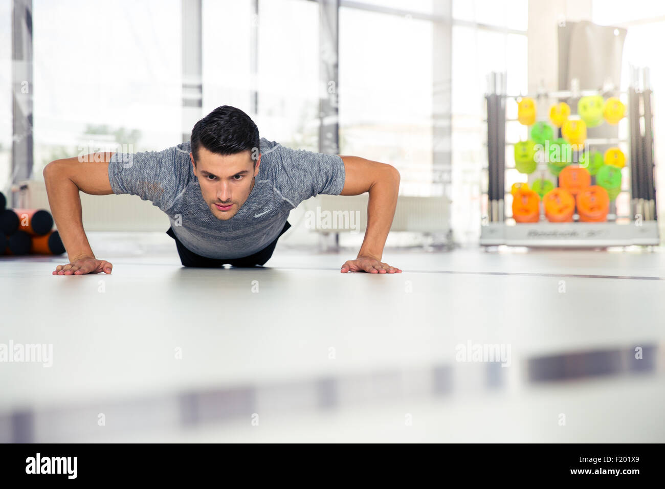 Portrait of a fitness man doing push-ups at gym Stock Photo - Alamy