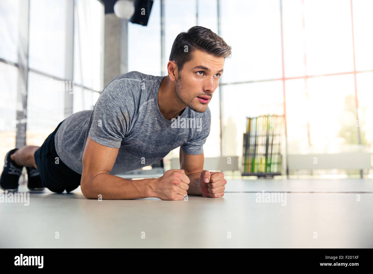Portrait of a fitness man doing planking exercise in gym Stock Photo ...