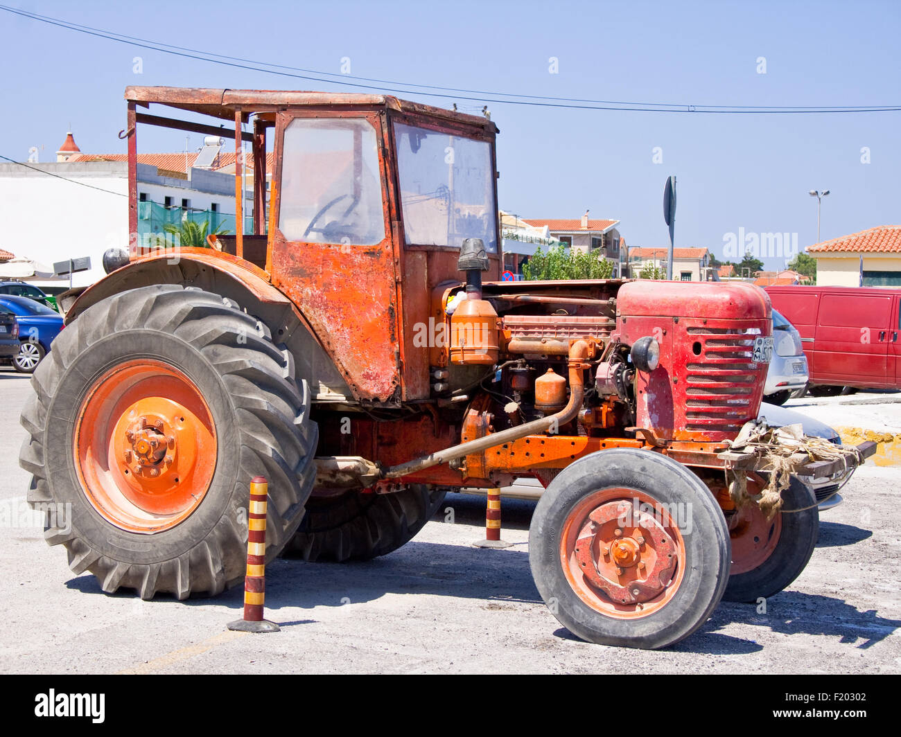 Orange Tractor in a car parking Stock Photo - Alamy