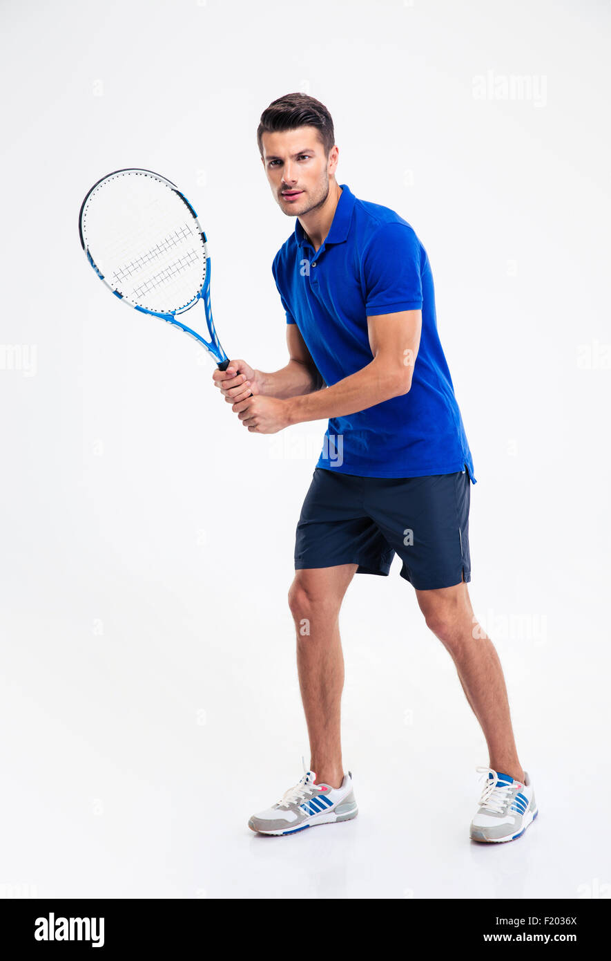 Full length portrait of a young man playing in tennis isolated on a ...