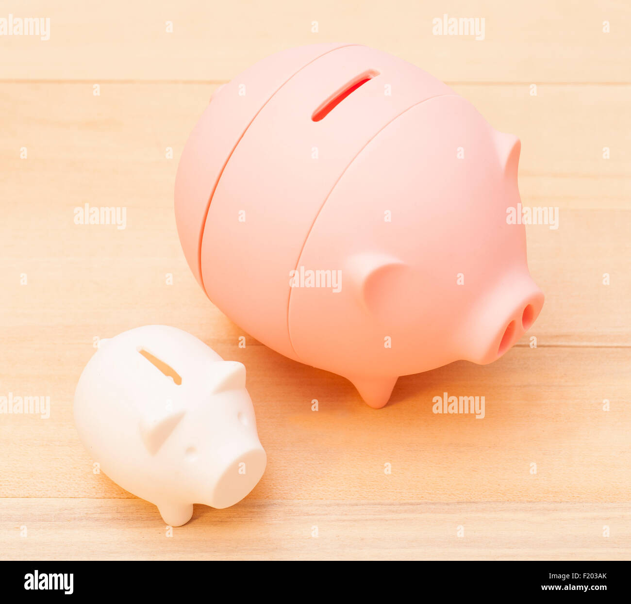 Two Piggy Banks on wood table Stock Photo - Alamy