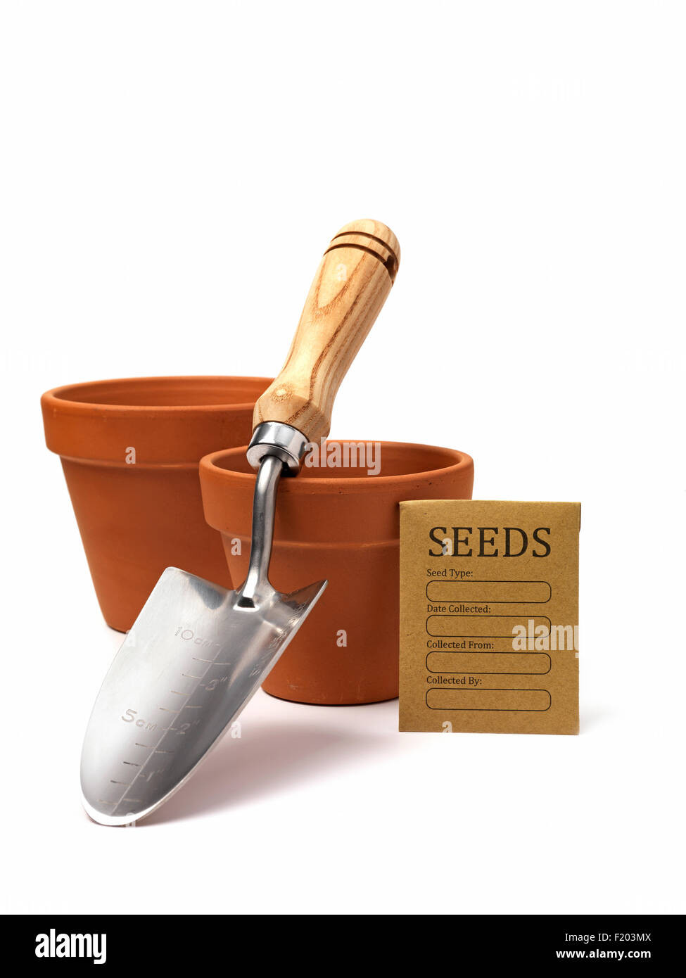 terracotta pot with a seed packet and garden trowel Stock Photo - Alamy