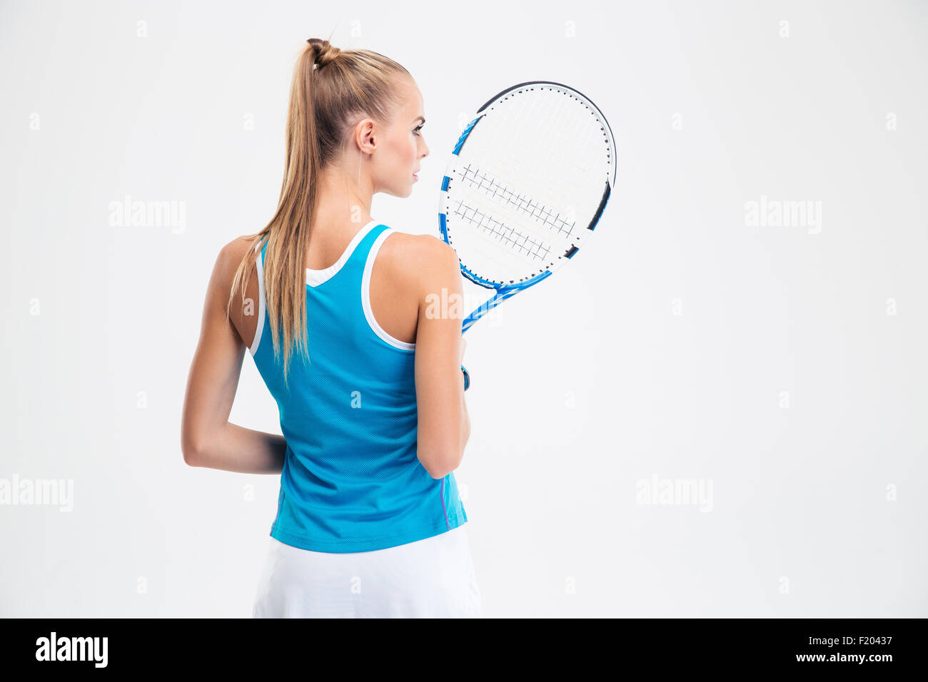 Back view portrait of a female tennis player standing isolated on a ...