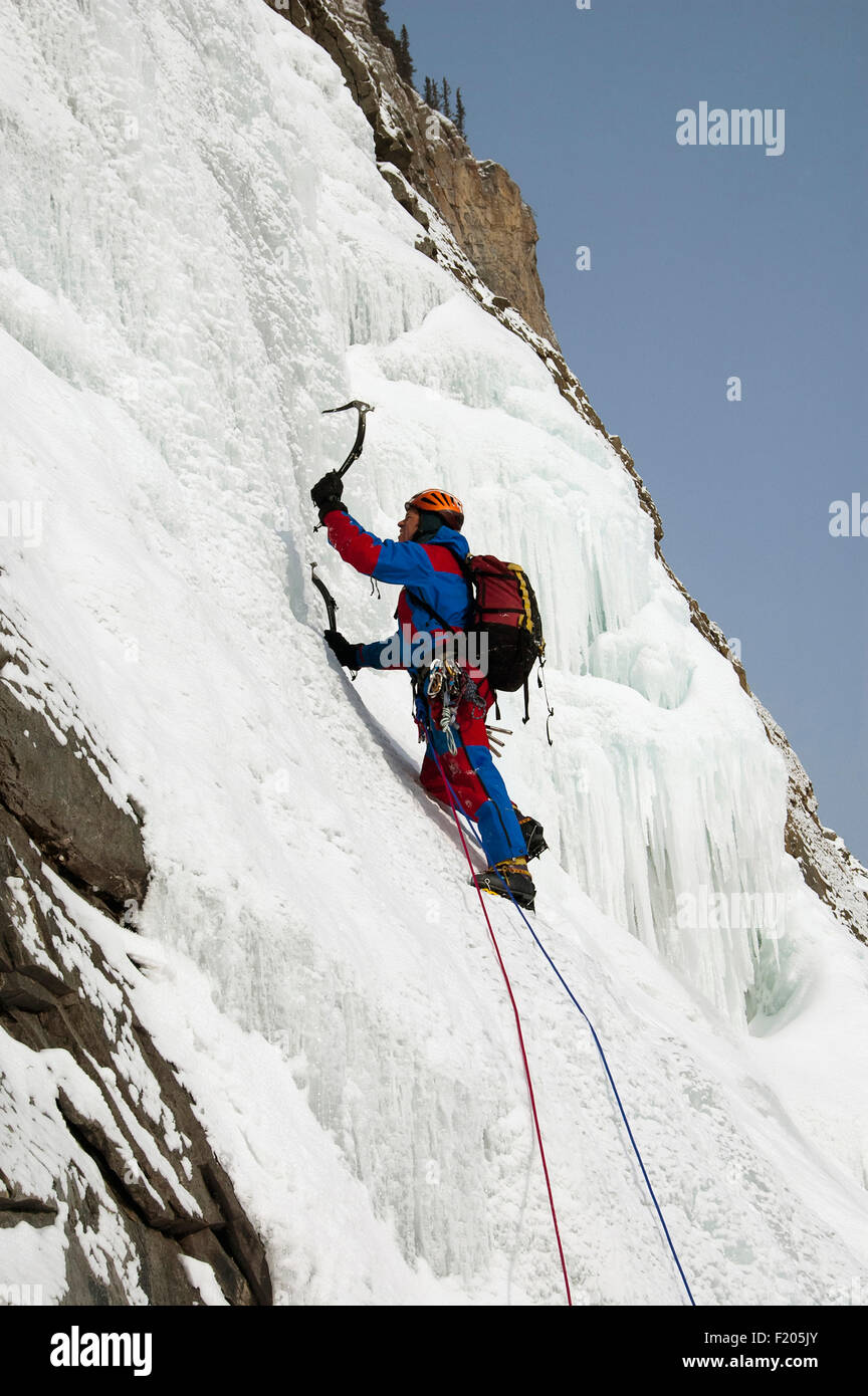 Canada, Alberta, Banff National Park, Ice climber climbing Cascade ...