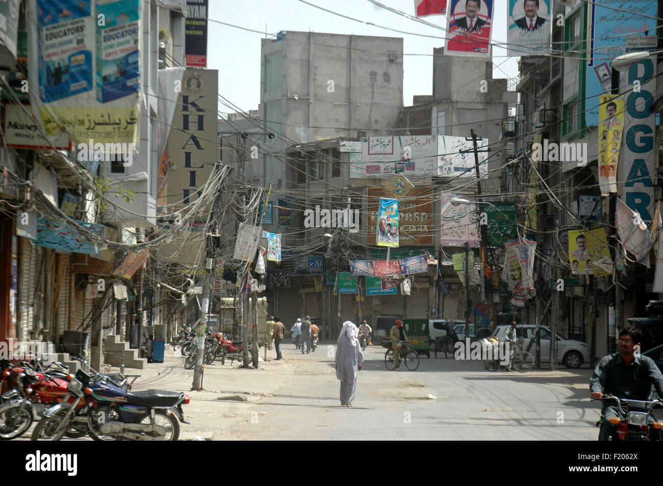 Lahore. 9th Sep, 2015. People walk past closed shops at a market during ...