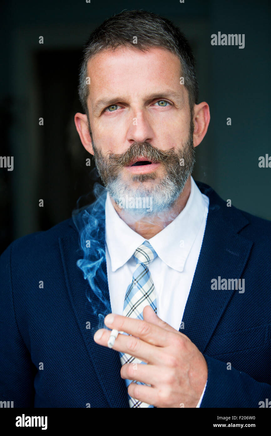 portrait of a handsome businessman smoking a cigarette Stock Photo - Alamy