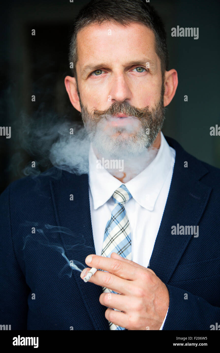 portrait of a handsome businessman smoking a cigarette Stock Photo - Alamy