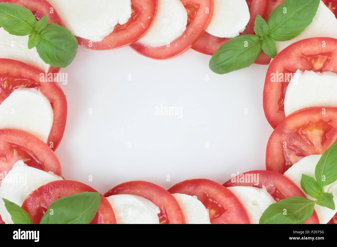 Tomato, mozzarella and basil leaves - isolated frame Stock Photo - Alamy
