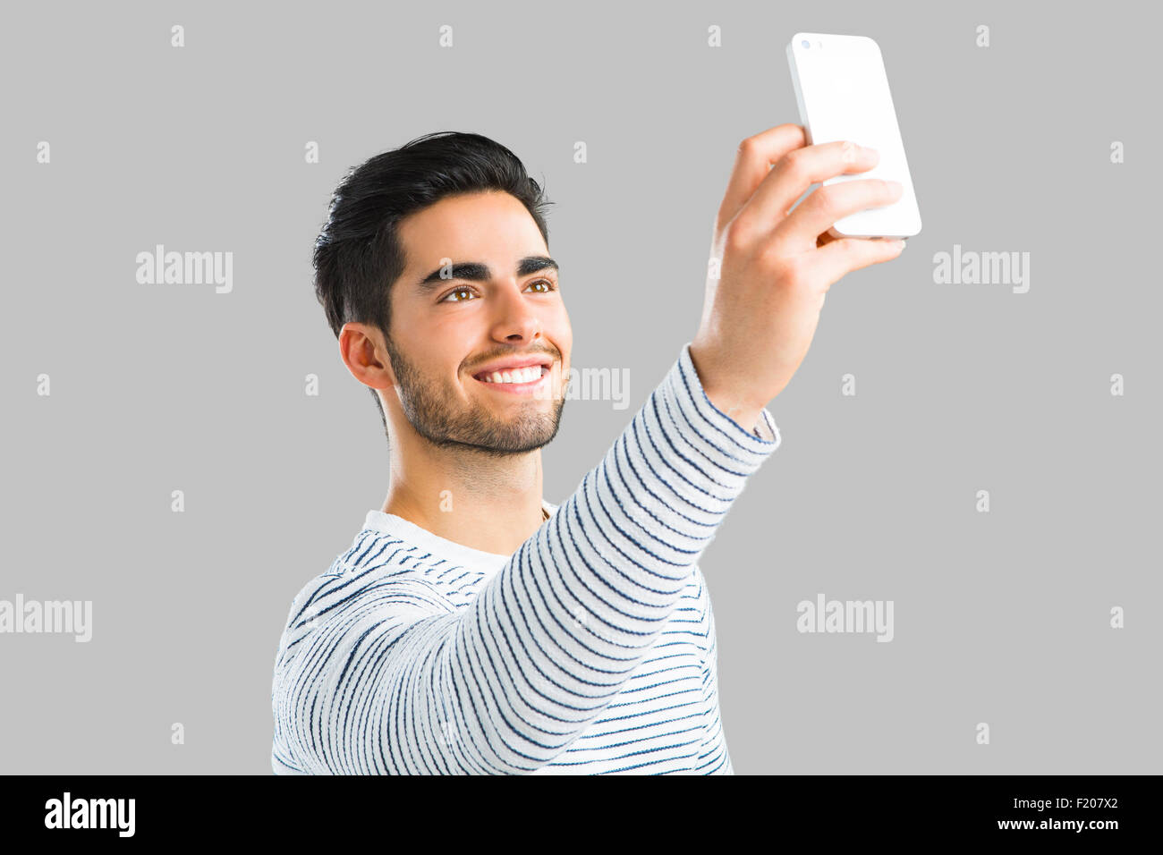 Handsome young man making a selfie picture with phone, isolated over ... Handsome young man making a selfie picture with phone, isolated over ...