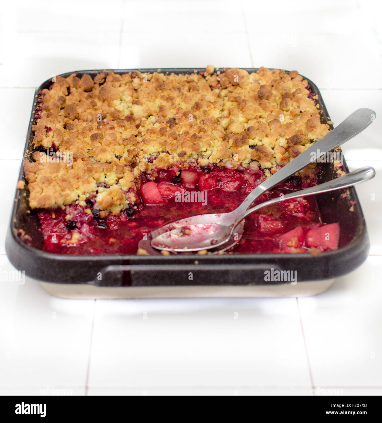 A red berrie crumble with two spoons on a white background Stock Photo ...
