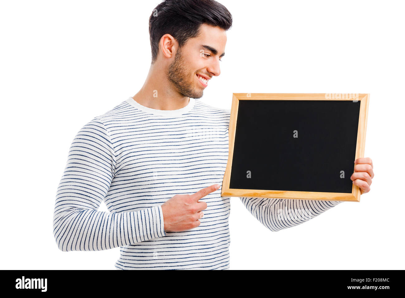 Handsome young man holding and pointing to a small chalkboard, isolated ...