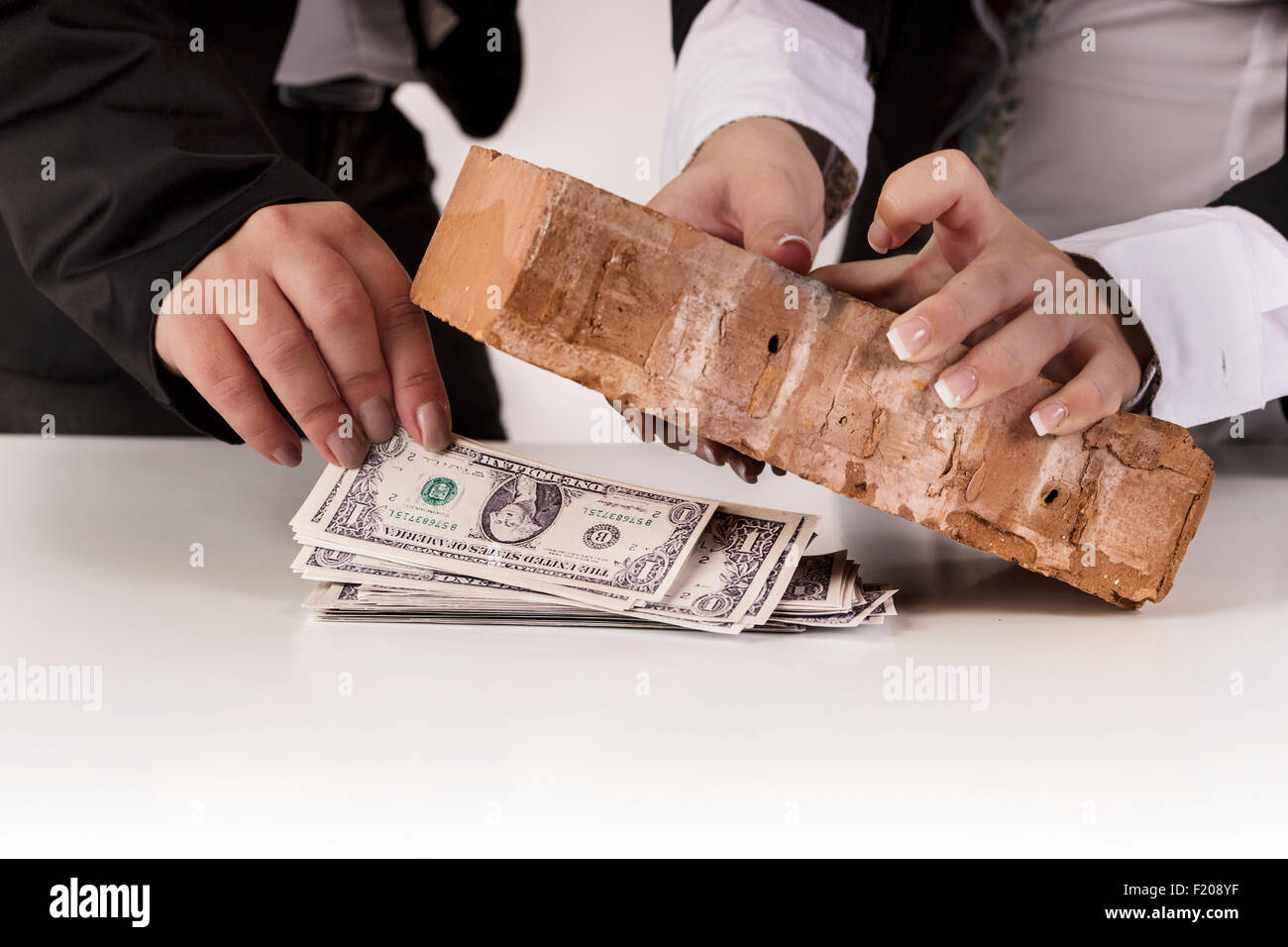 dollars under the brick Stock Photo - Alamy