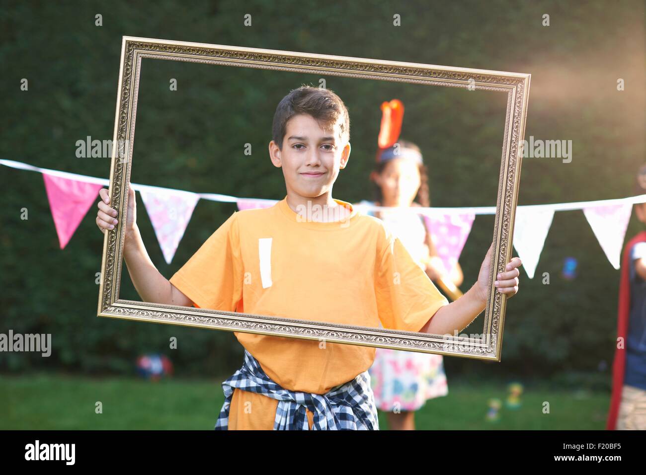 Portrait of boy looking through picture frame, looking at camera Stock ...