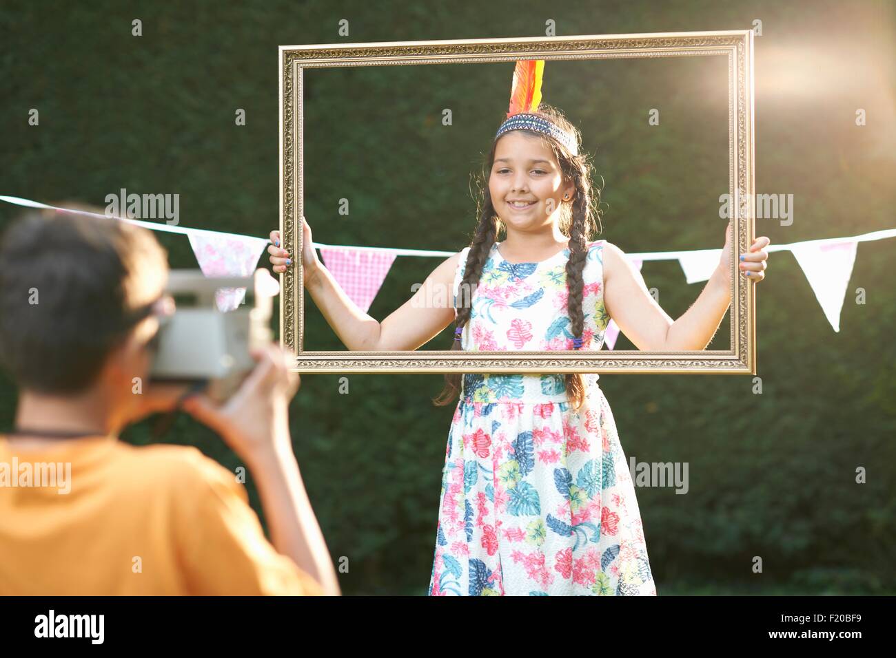 Girl looking through picture frame, having photograph taken Stock Photo ...