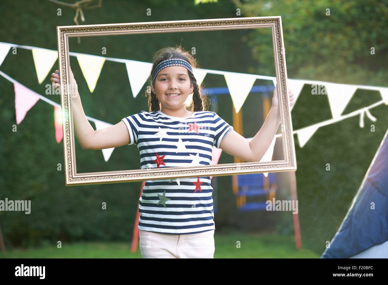Girl looking through picture frame, looking at camera smiling Stock ...