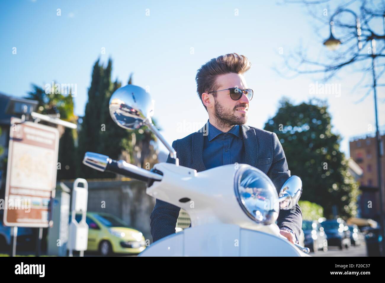Stylish young man on moped Stock Photo - Alamy