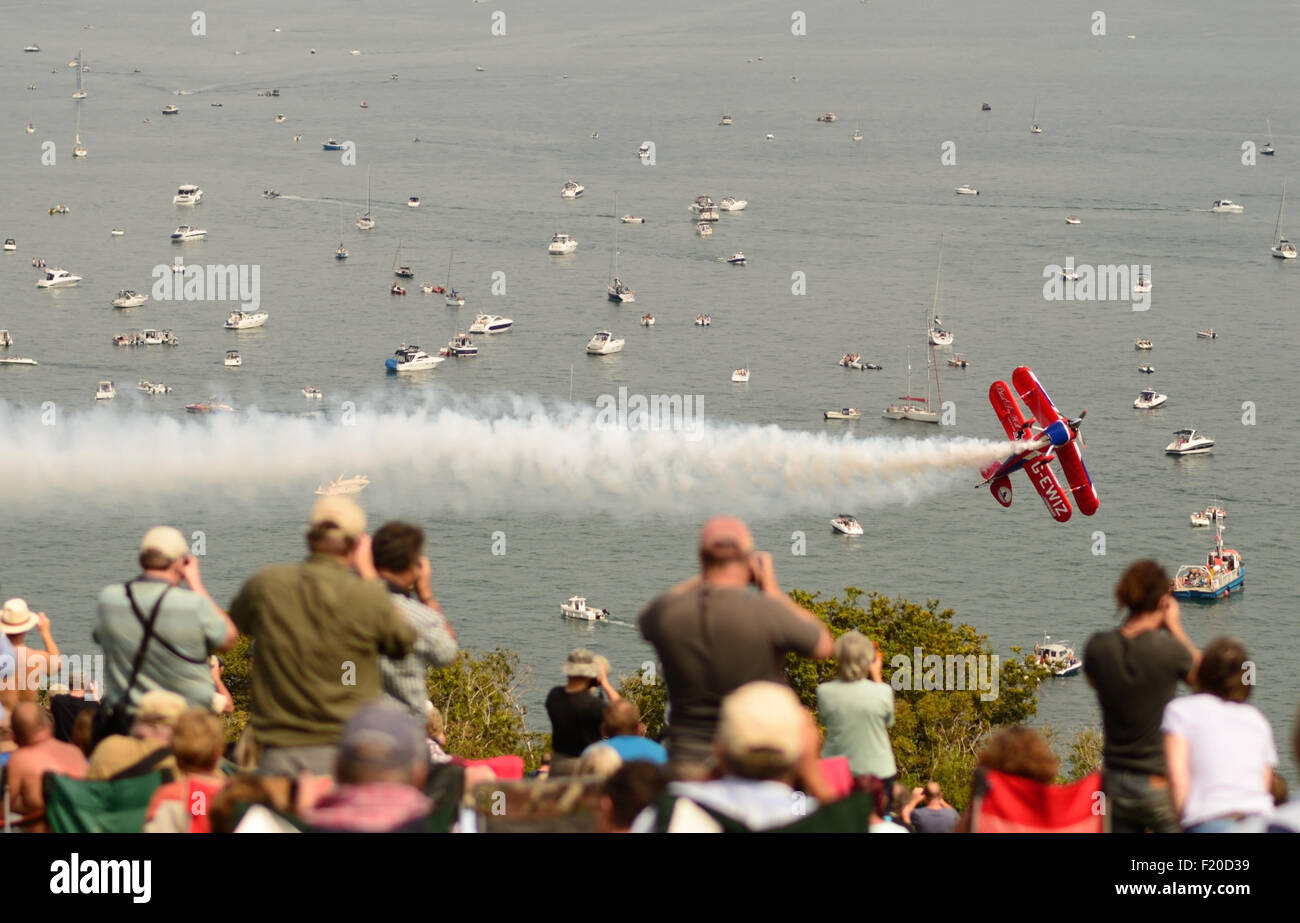 Spectators watching Rich Goodwin's Muscle biplane performing aerobatic ...