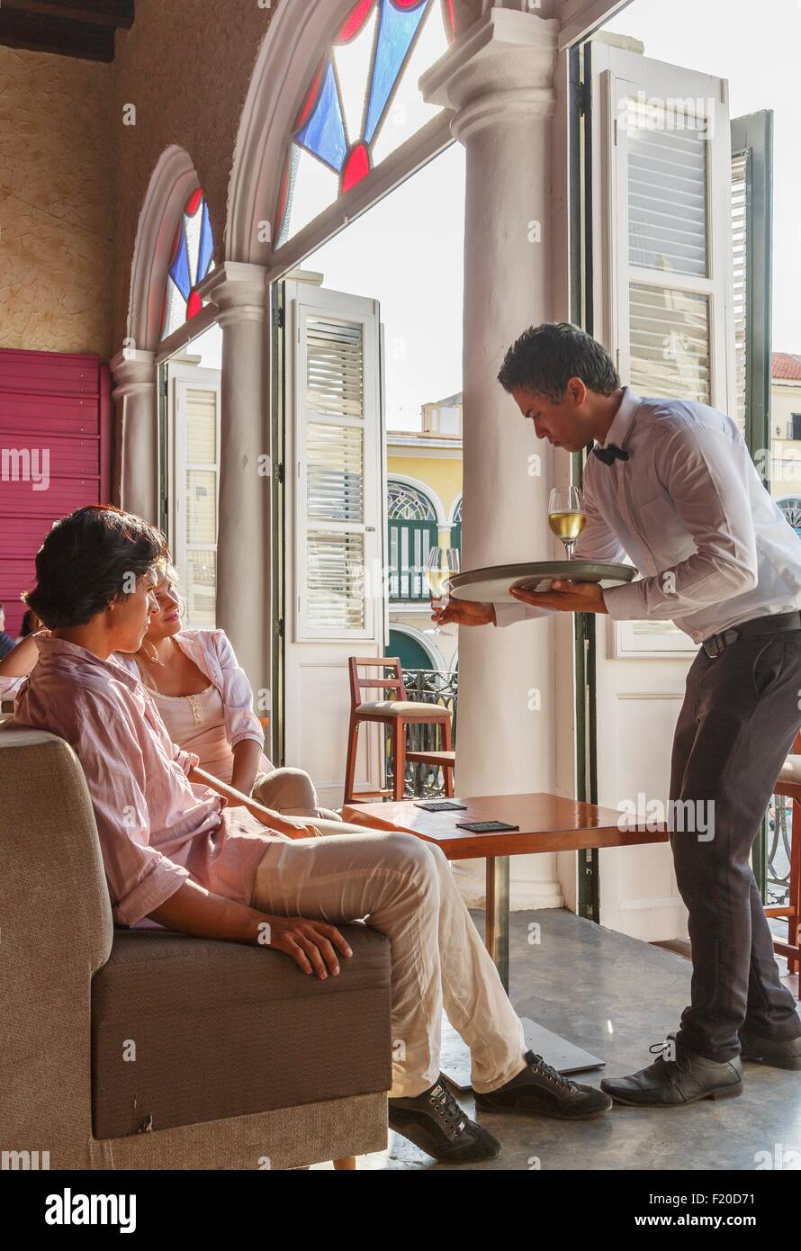 Young couple being served wine in restaurant, Havana, Cuba Stock Photo ...