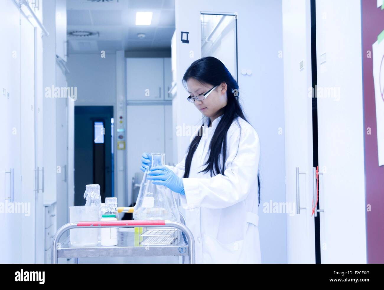 Female scientist preparing experiment equipment for trolley in ...