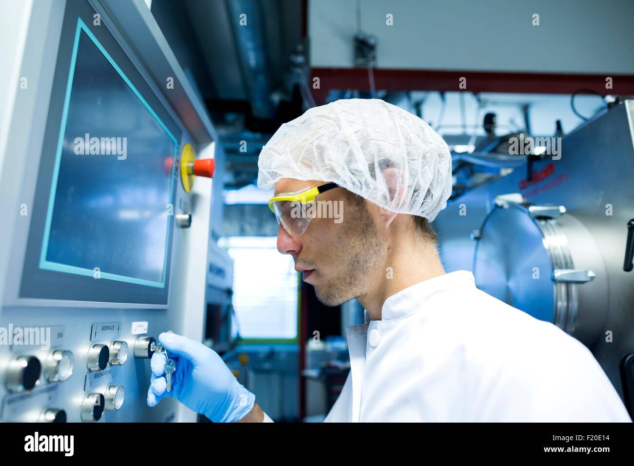 Male scientist adjusting switch on control panel in lab cleanroom Stock ...