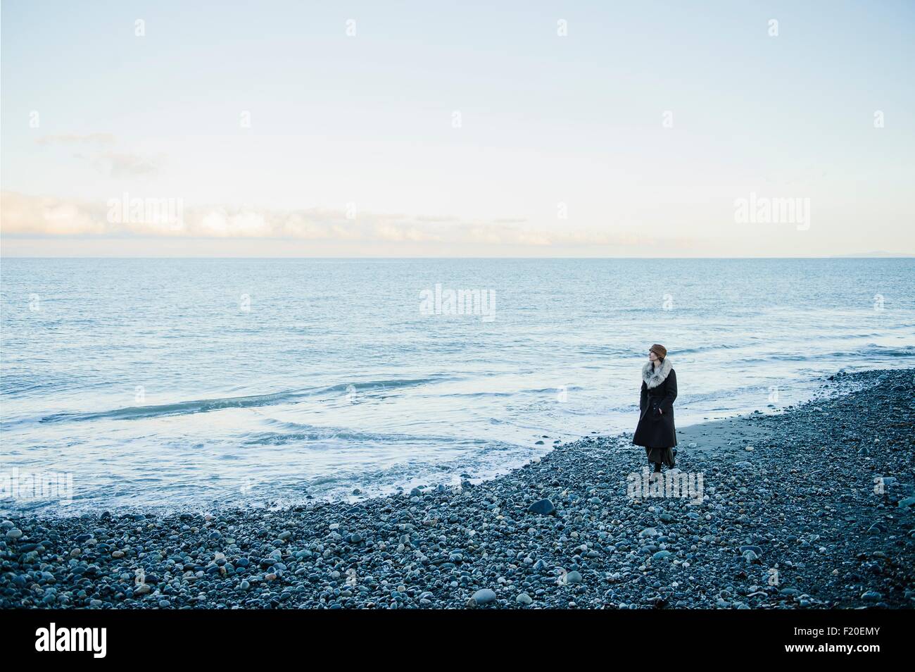 Woman strolling on beach Stock Photo - Alamy