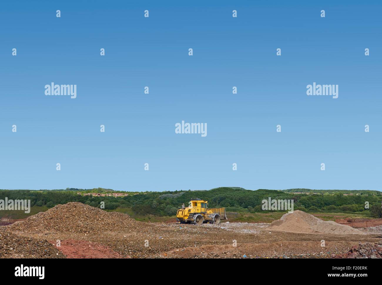 Digger burying waste on landfill site Stock Photo - Alamy