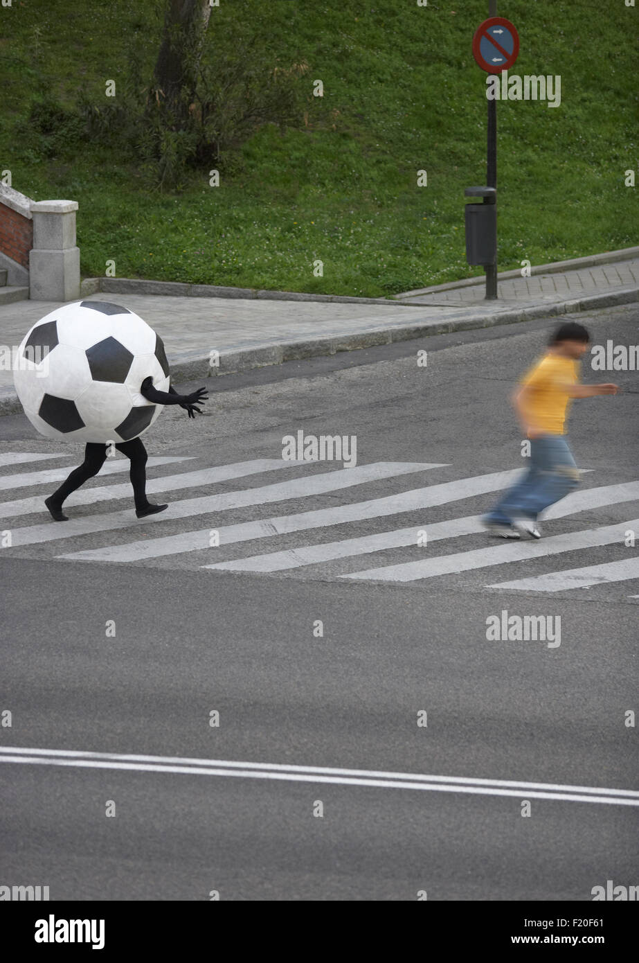 Man with a soccer ball disguise running on a street Stock Photo - Alamy