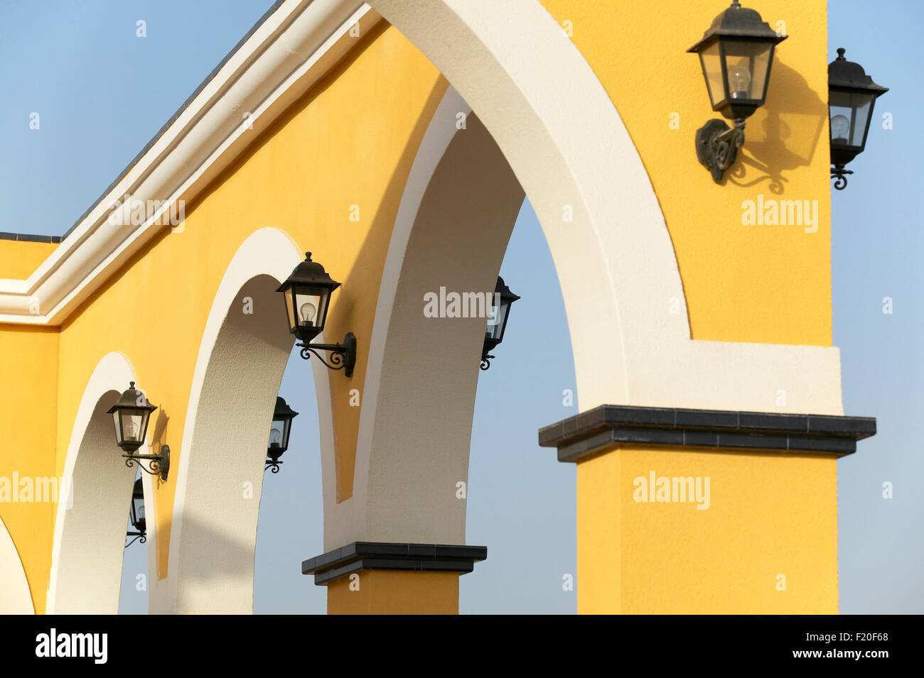 Electric lamps on a yellow wall with arches Stock Photo - Alamy