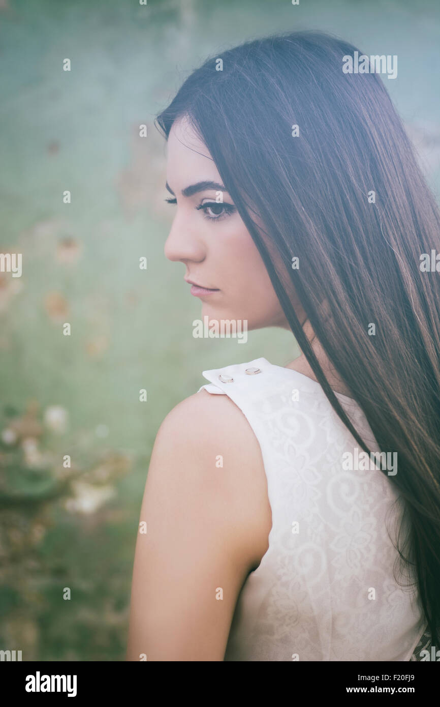 Serious young woman looking over shoulder outdoors Stock Photo - Alamy