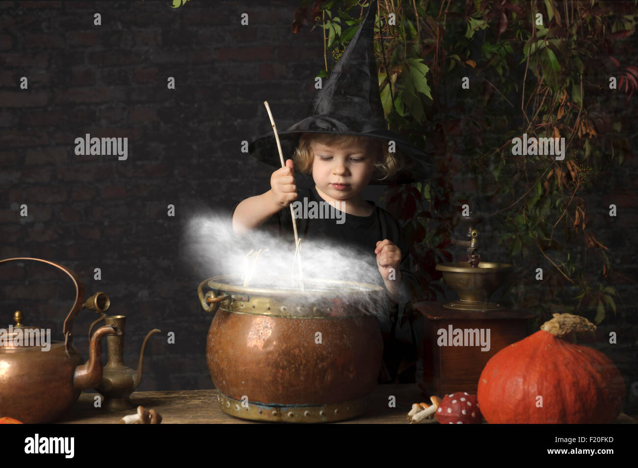 little halloween witch with boiling cauldron Stock Photo - Alamy
