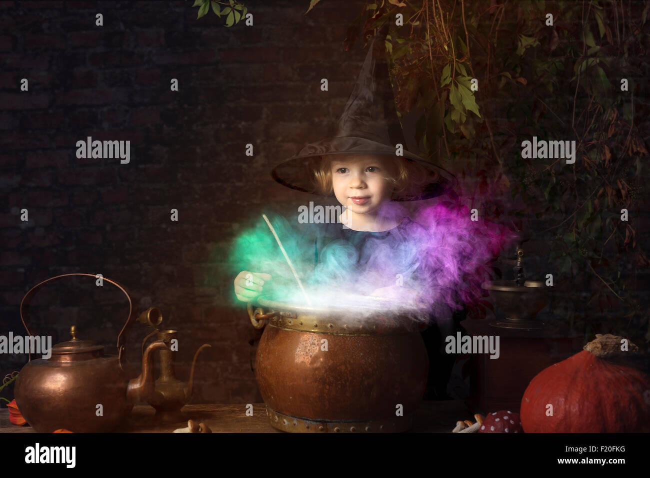 little halloween witch with boiling cauldron Stock Photo - Alamy