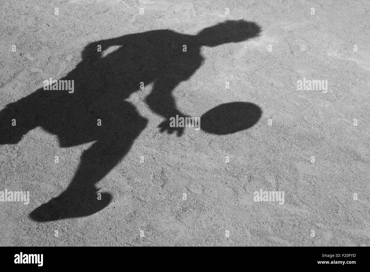 Shadow of a football player reflected on sand Stock Photo - Alamy