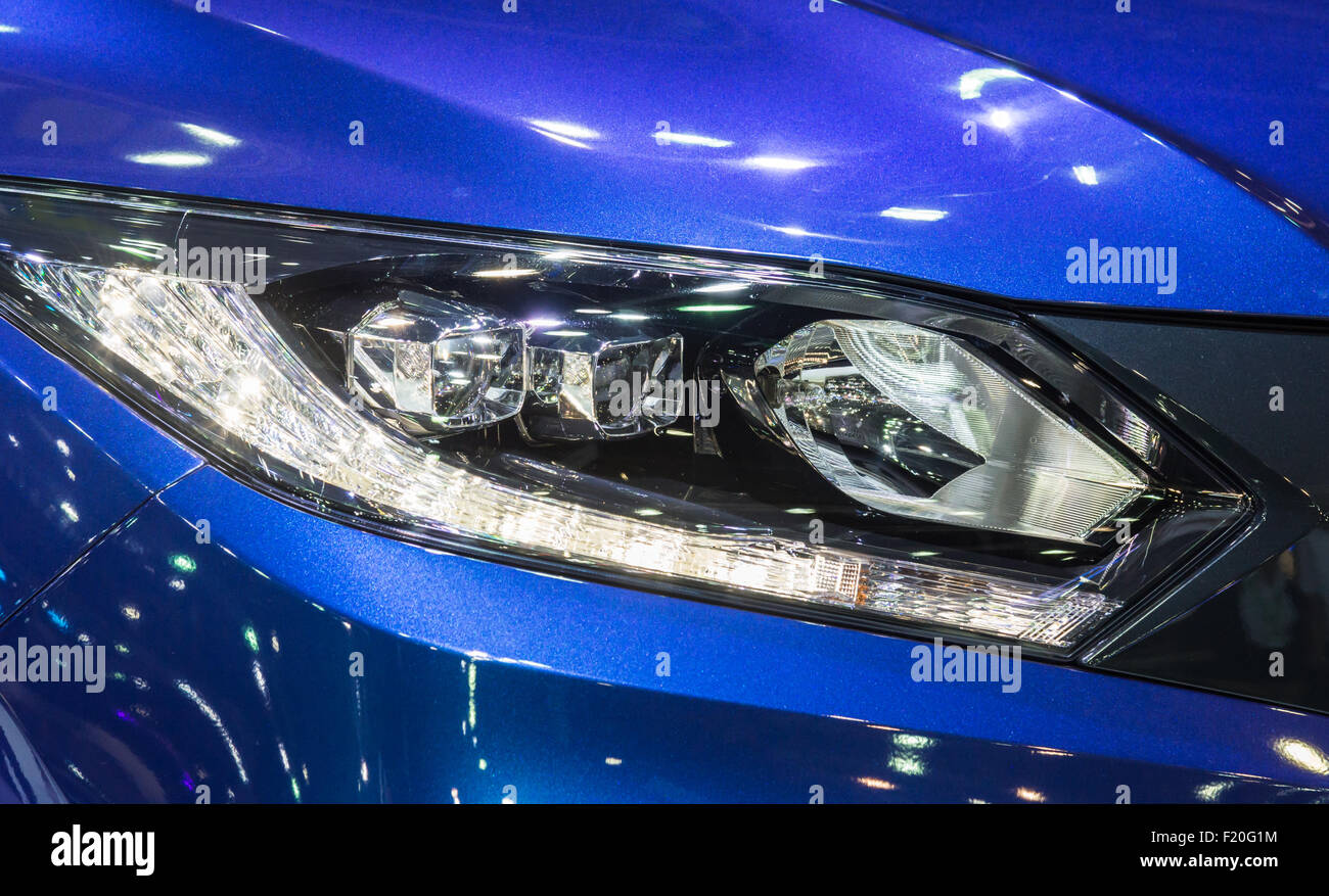 Modern headlight of the blue compact car Stock Photo - Alamy