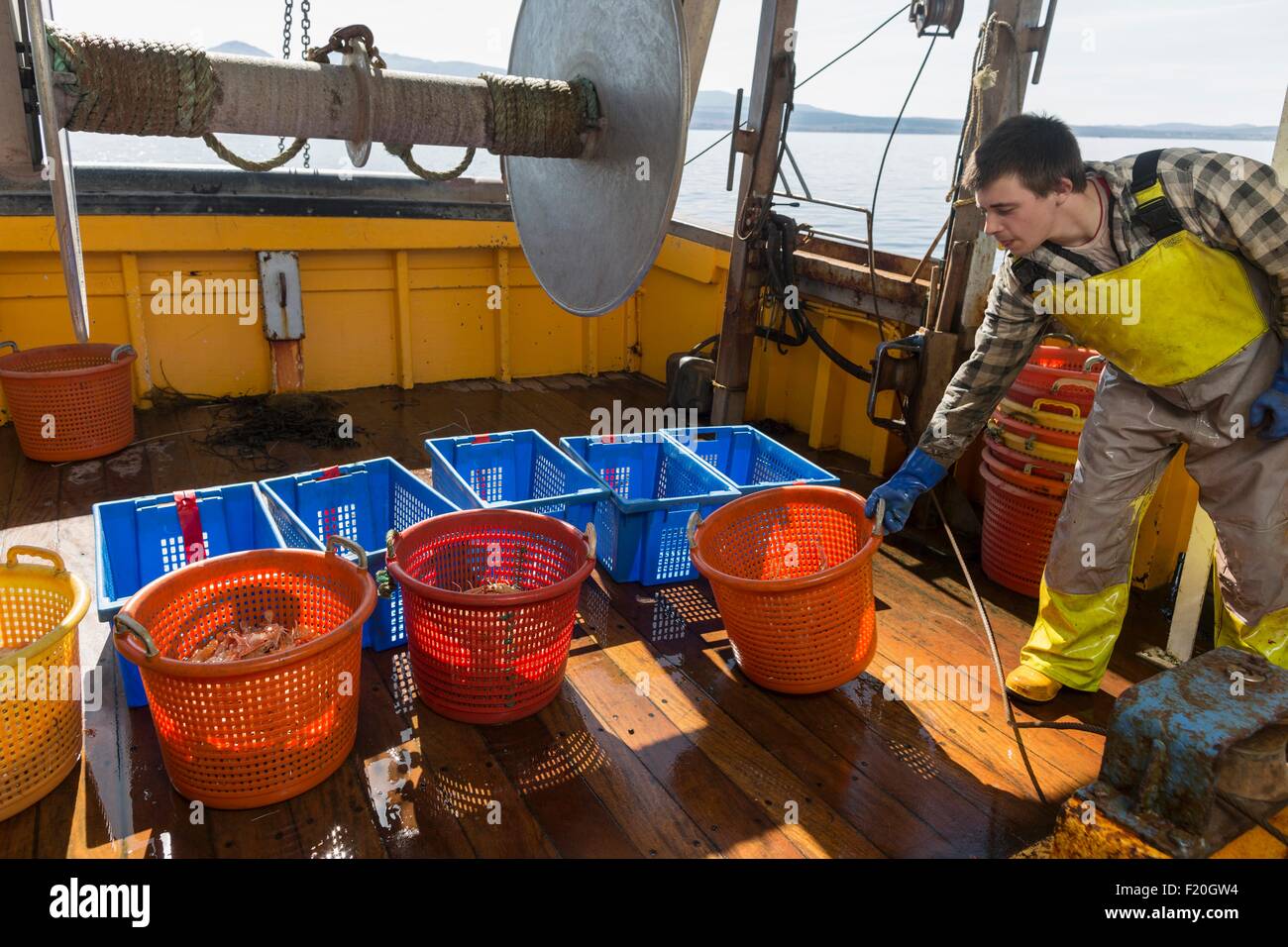 Fisherman with baskets of shellfish Stock Photo - Alamy
