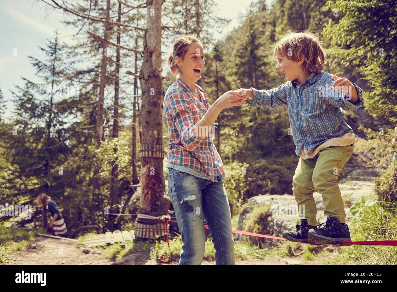 Boy balancing on rope with help from mother, Ehrwald, Tyrol, Austria ...