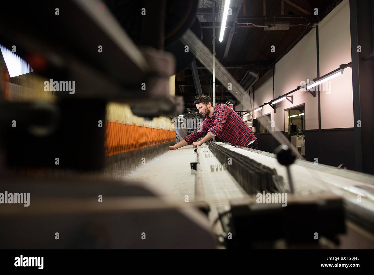 Young male weaver working at old weaving machine in textile mill Stock ...