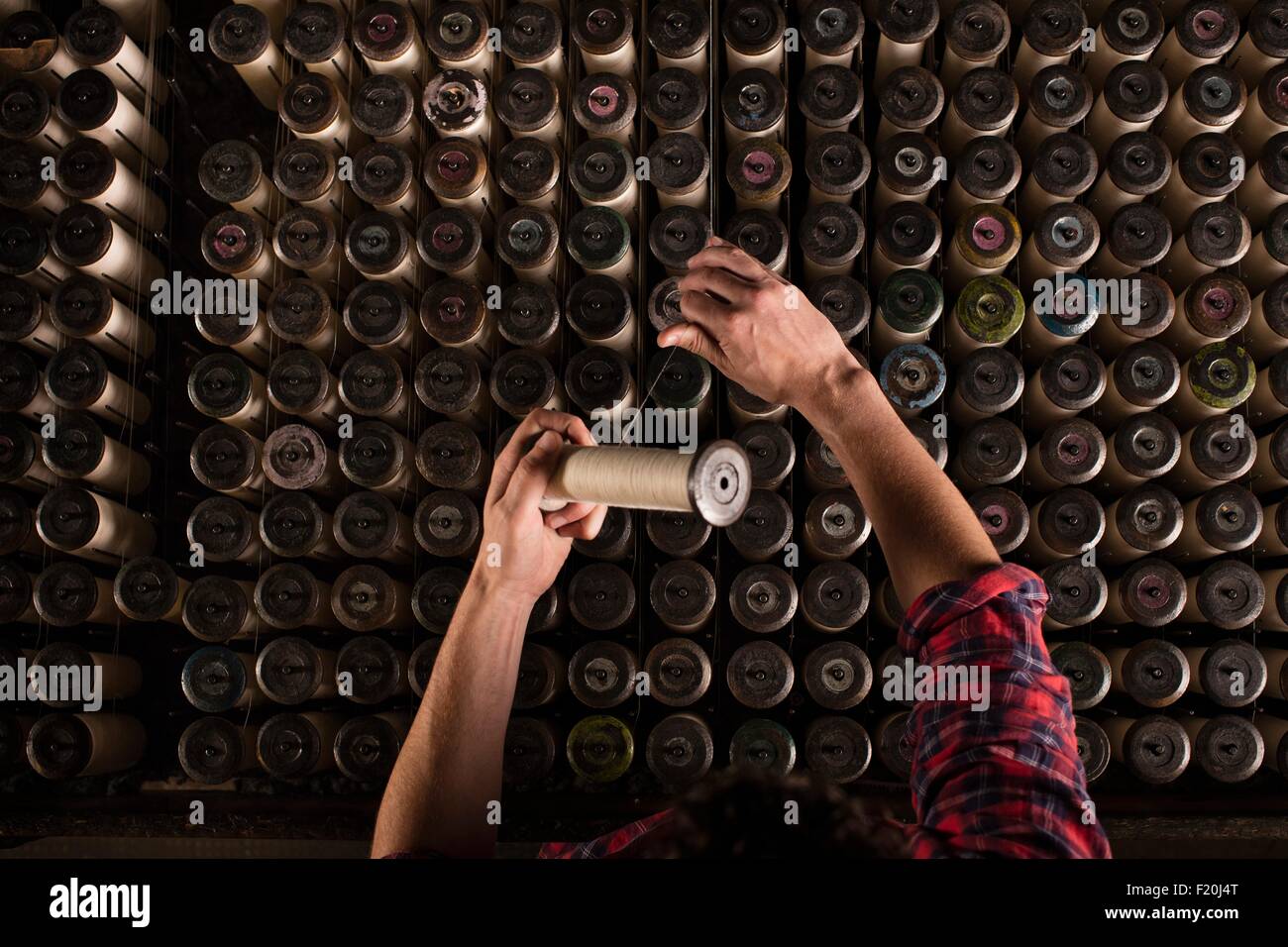 Hands of male lace weaver replacing threads on old weaving machine in ...