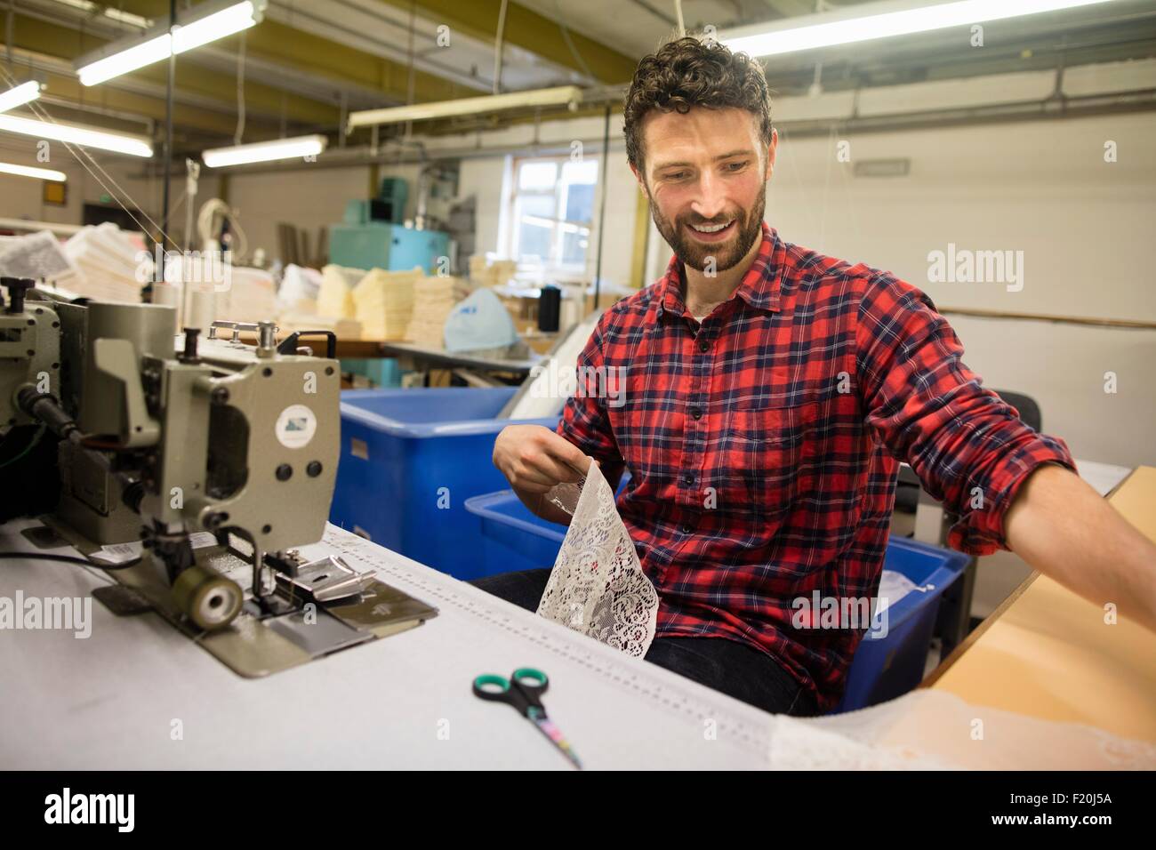 Male weaver finishing lace on sewing machine in old textile mill Stock ...