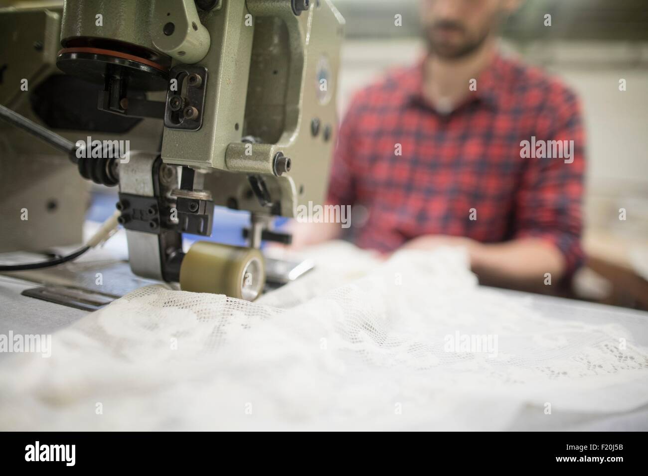 Male weaver sewing lace on sewing machine in old textile mill Stock ...