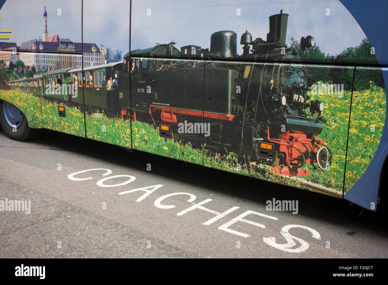 A tourist coach parked in central London shows an old steam train and ...