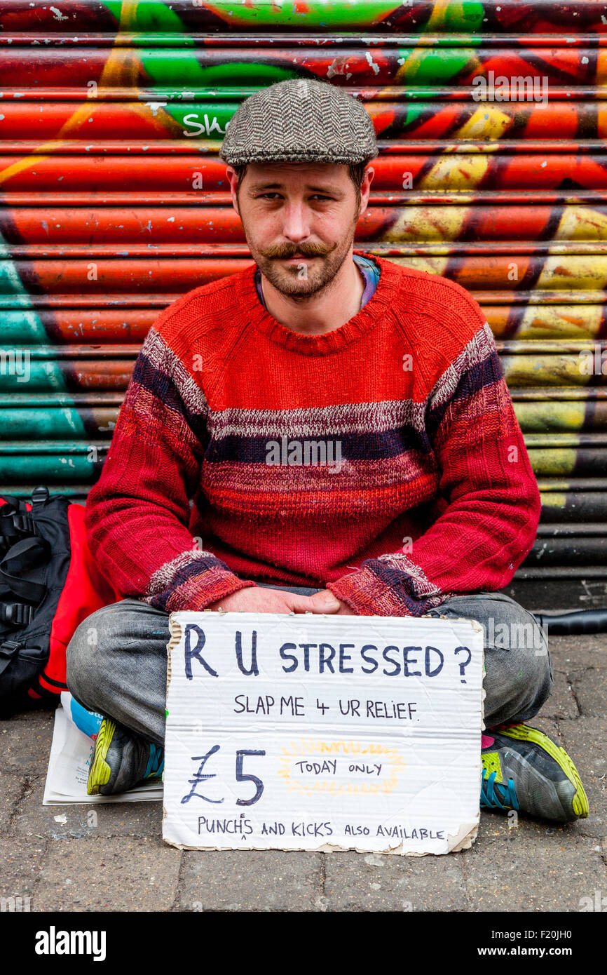 A Young Man Holds A Sign Asking If Passers By Would Like To Slap, Punch ...