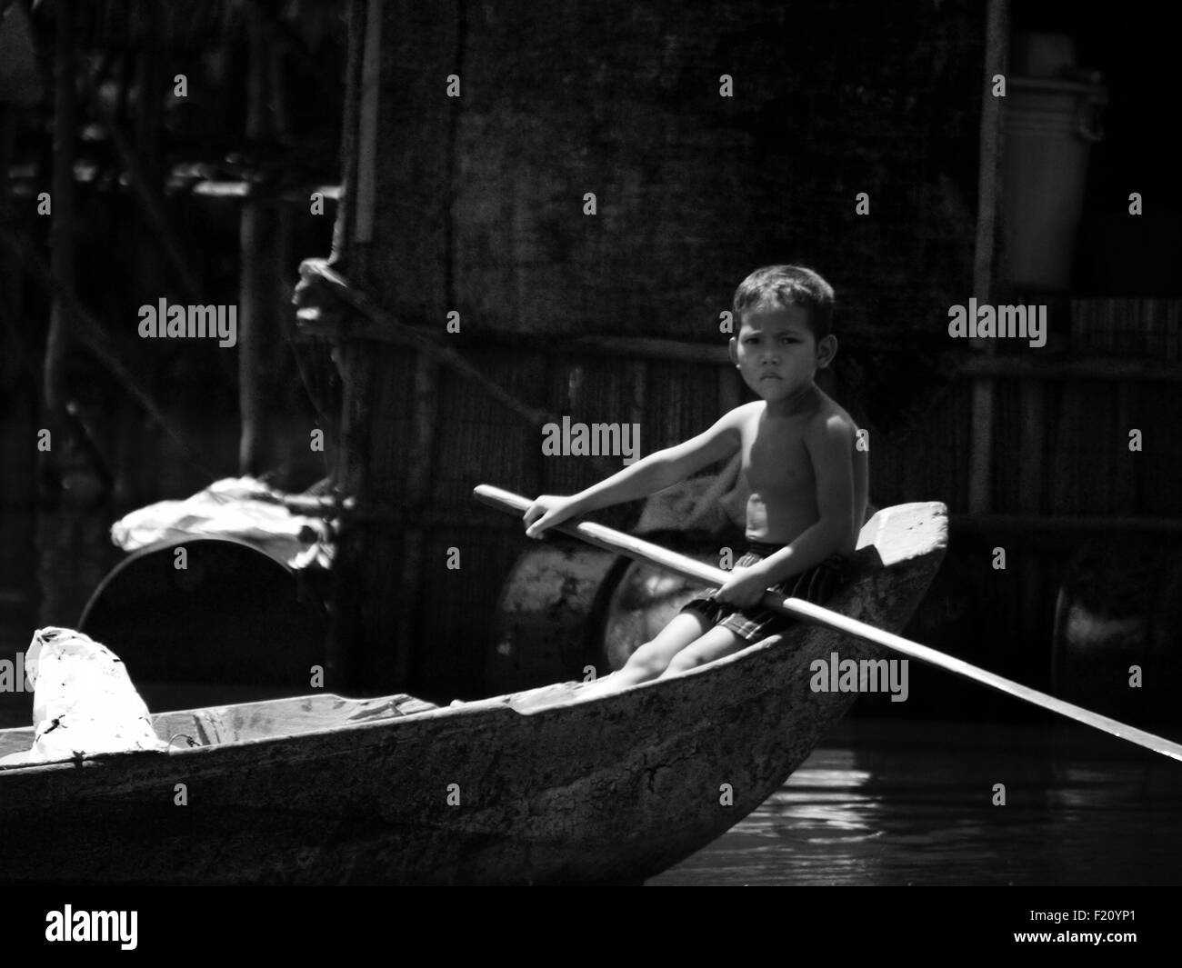 young boy rowing a boat in Cambodia Stock Photo - Alamy