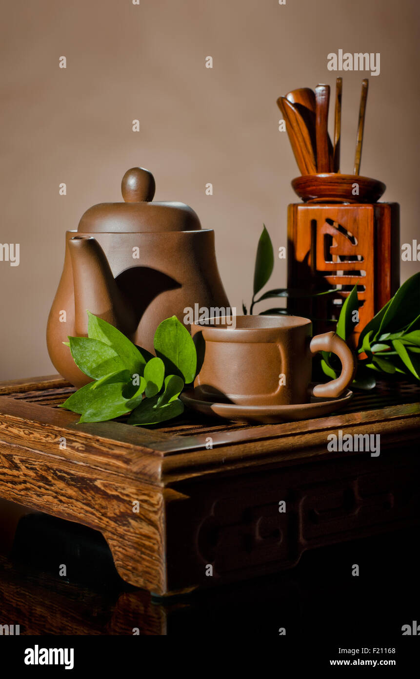 vertical photo, still life of the clay teapot and cup on brown ...