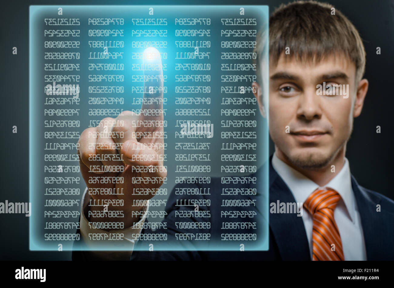 handsome businessman finger point touch sensor panel, on dark blue ...