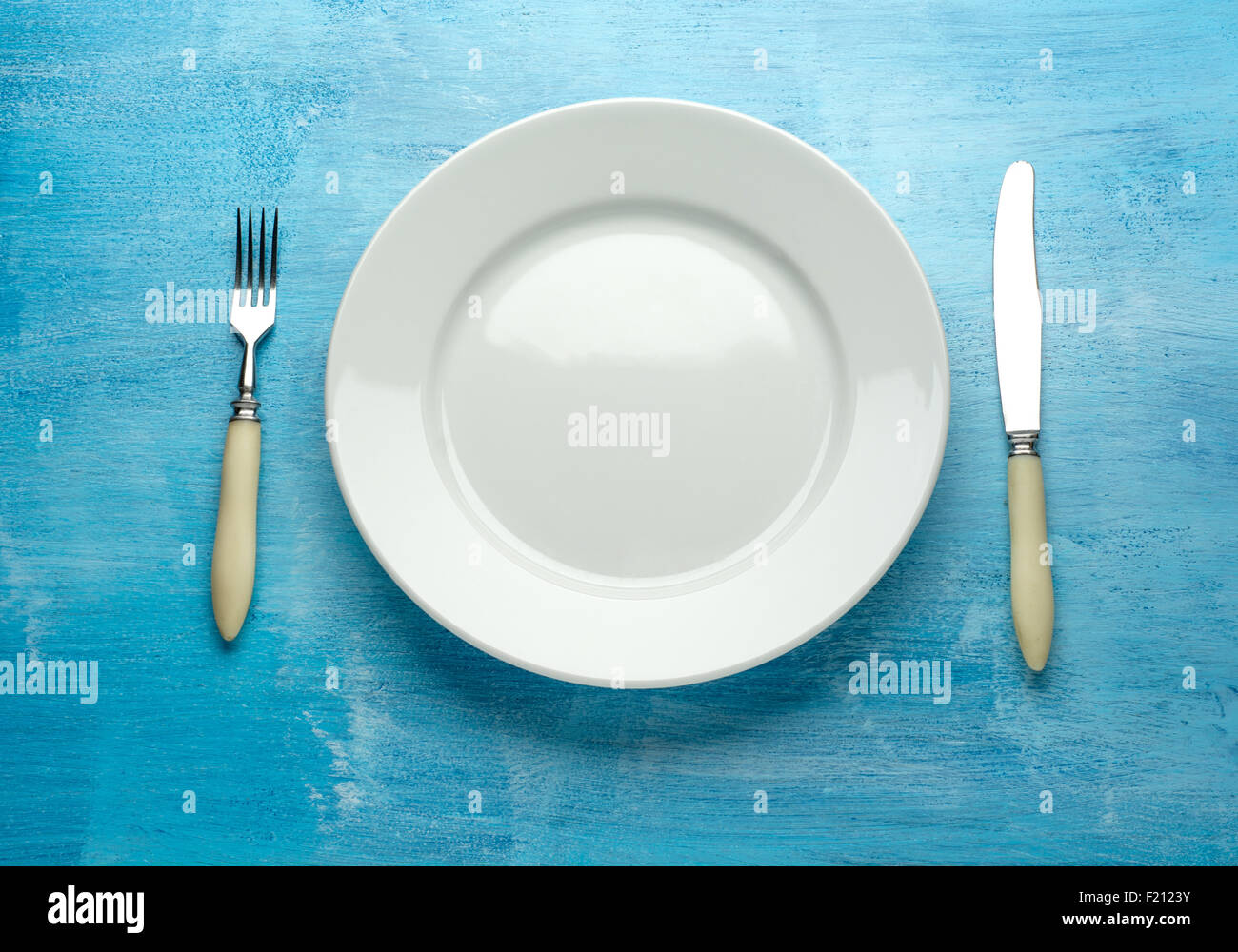 Fork with knife and blank plates. On wooden table Stock Photo - Alamy