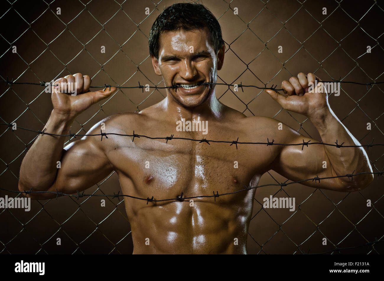 the very muscular handsome felon guy , out of netting steel fence with ...